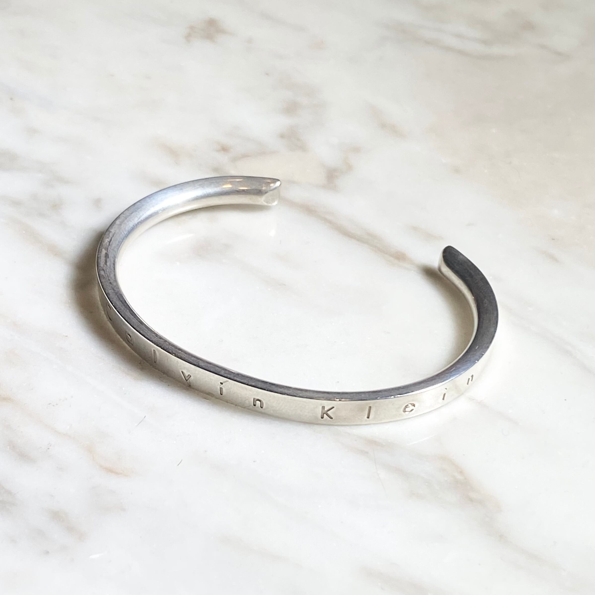 CALVIN KLEIN silver logo bangle for ladies | NOIR ONLINE